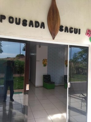 Entrada de hotel com uma placa indicando "POUSADA SACUI".