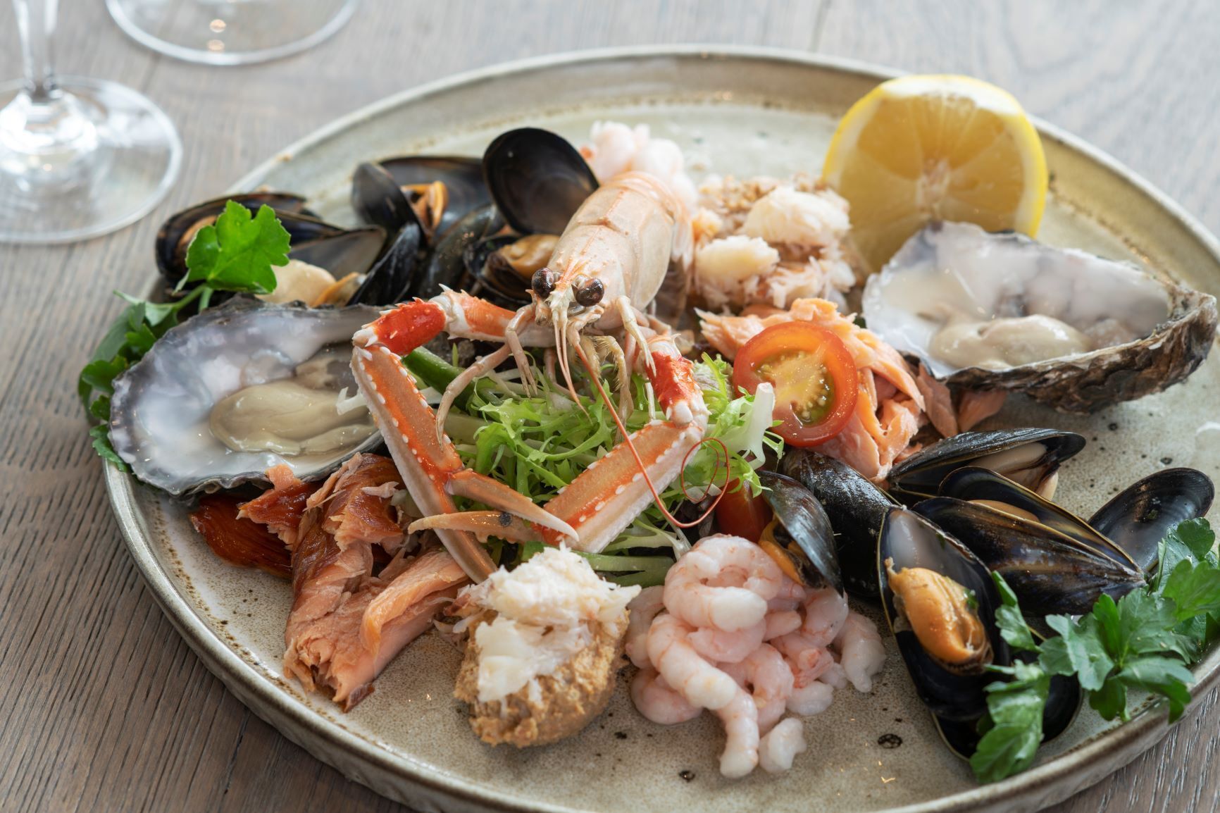 Prato de frutos do mar com diversos mariscos e uma fatia de limão.