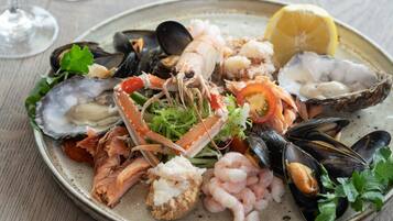 Prato de frutos do mar com diversos mariscos e uma fatia de limão.
