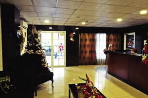 Um hall com balcão de recepção, uma grande árvore de Natal e uma área de estar.