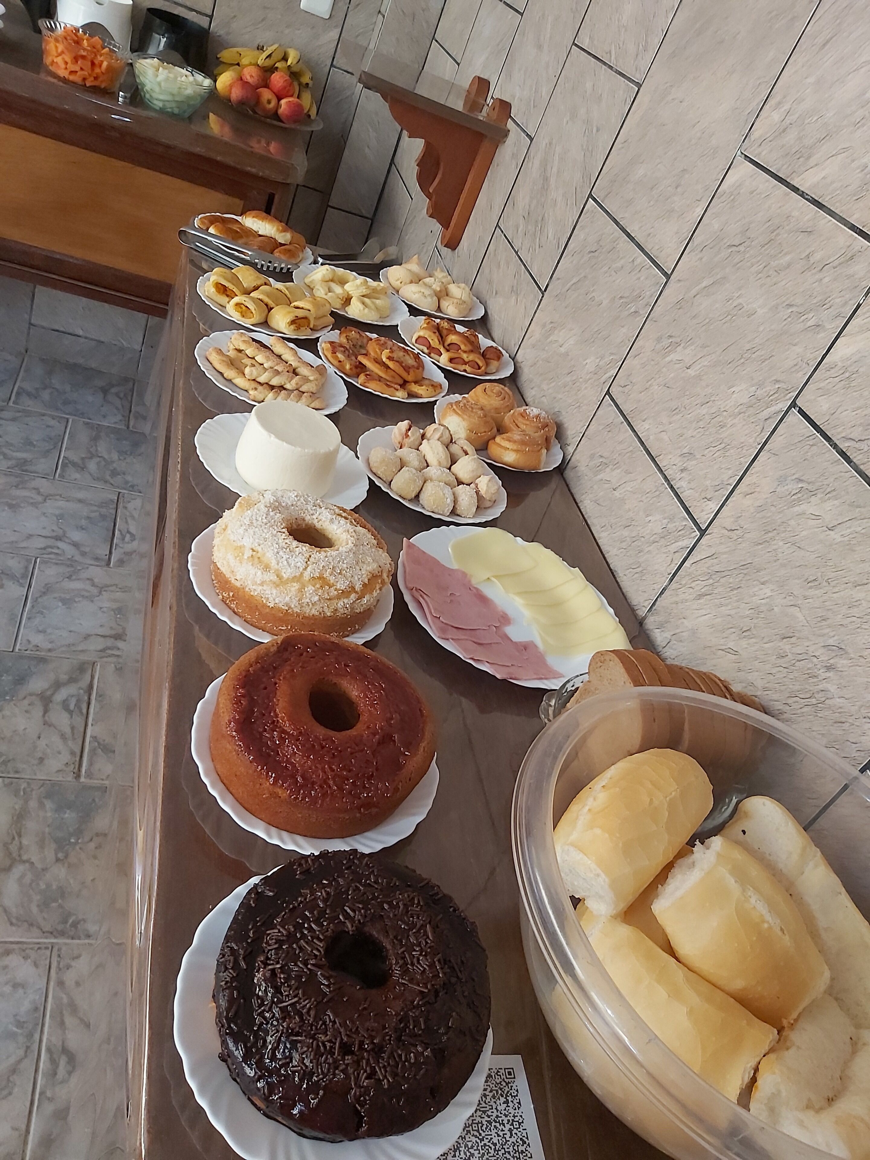 Uma mesa de buffet com diversos doces e produtos de pastelaria.