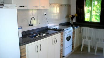 Um frigorífico, um forno, utensílios de cozinha