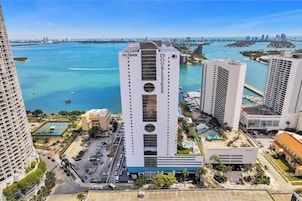 Hotel imponente com átrio central, rodeado por água e outros edifícios.