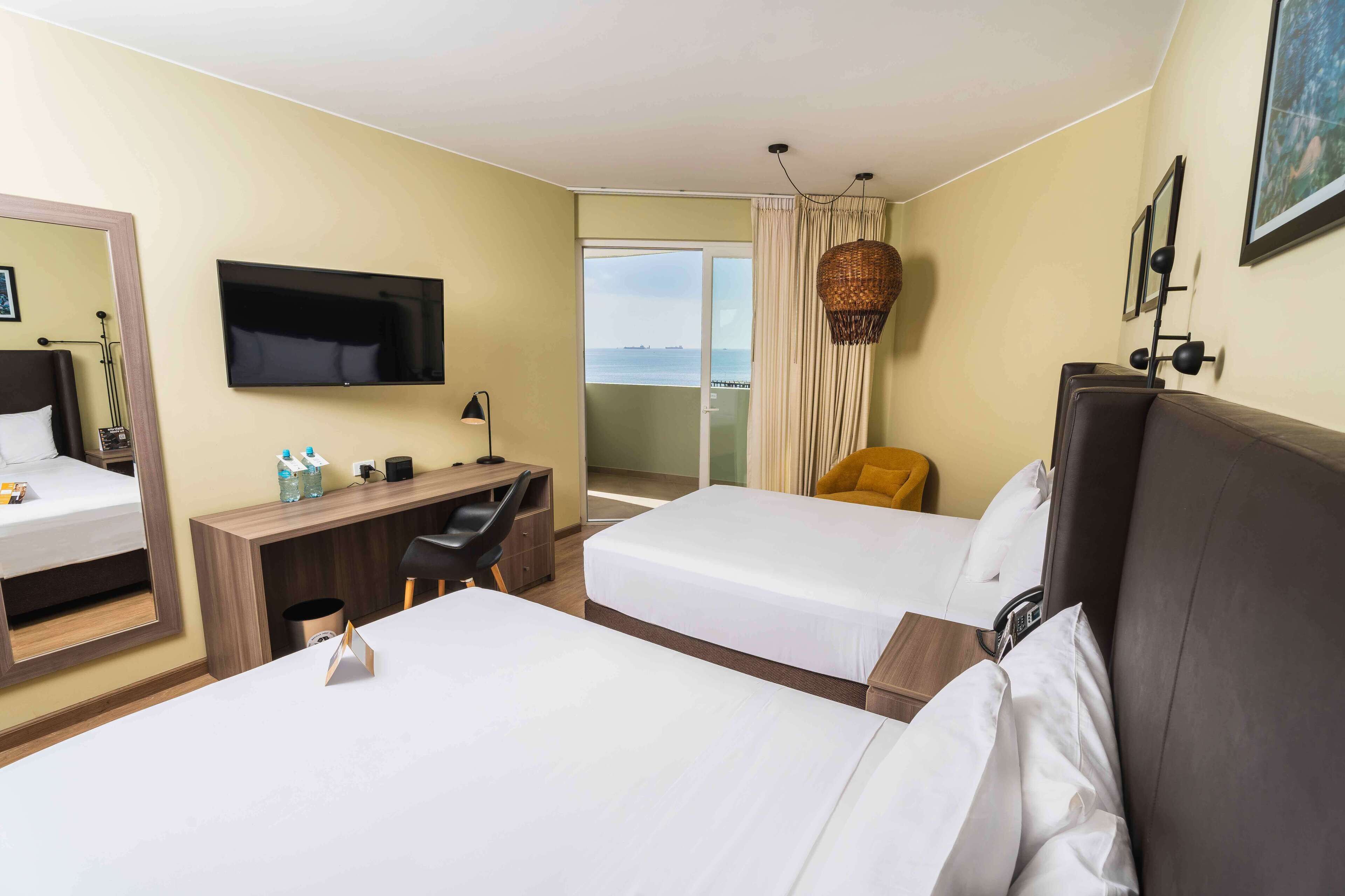 Suite, várias camas, vista para o mar | Cofre no quarto, secretária 