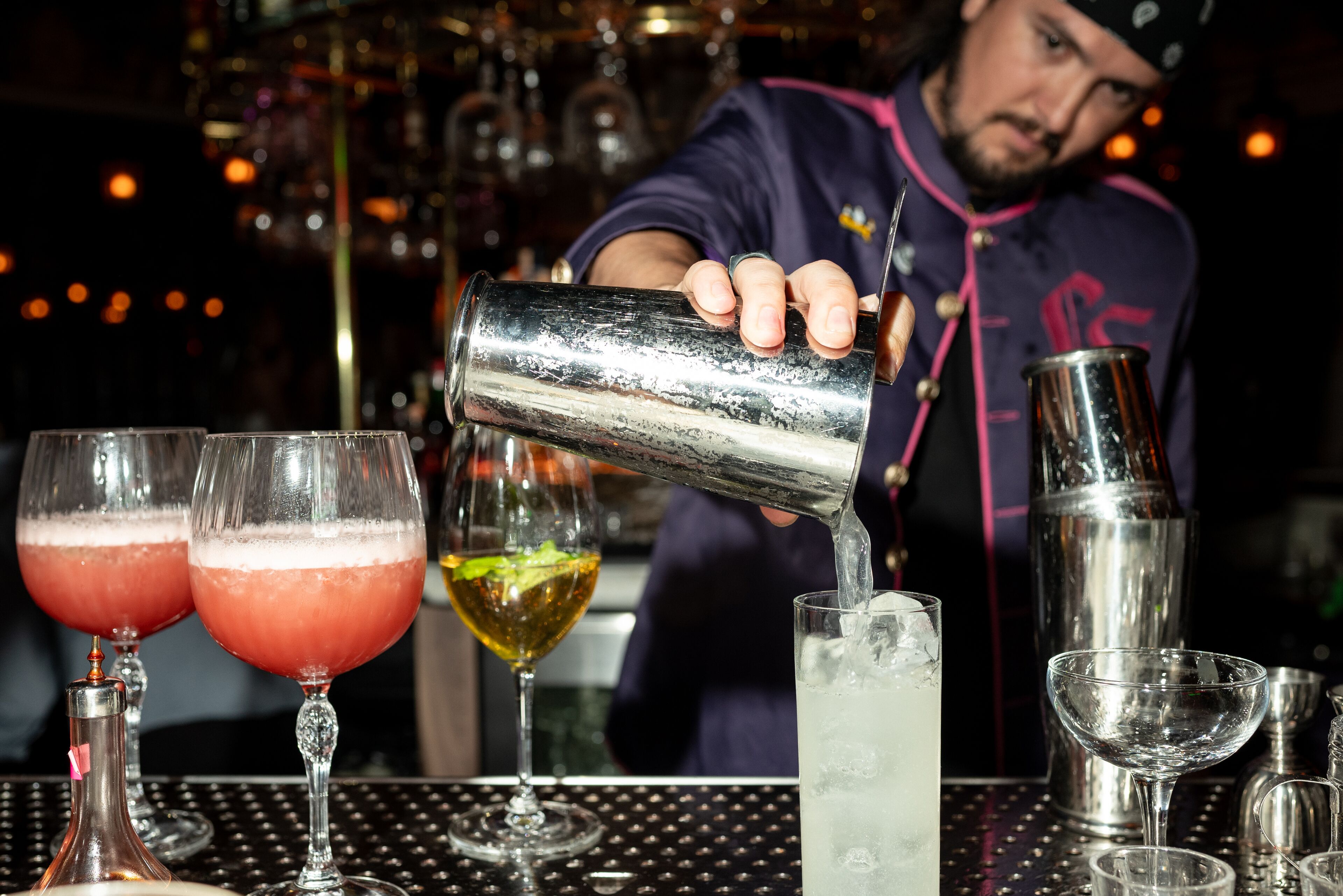 Um barman a servir uma bebida num copo.