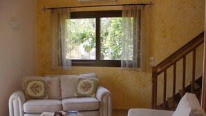 Uma sala de estar com um sofá, uma mesinha e uma escada.