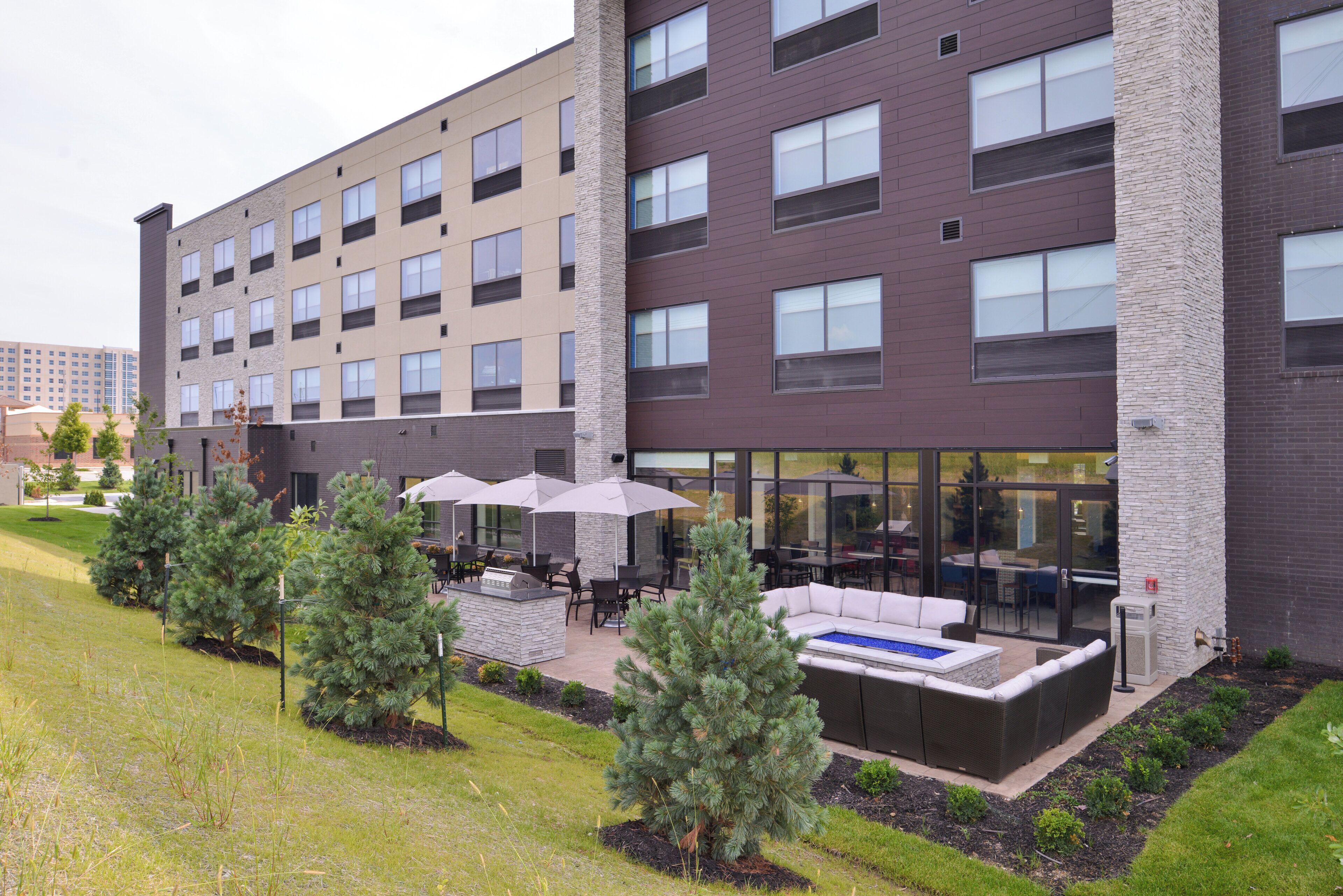Um hotel com vários andares, área de estar ao ar livre e piscina.
