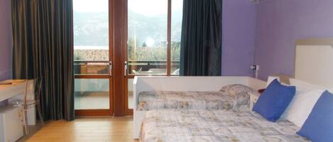 Quarto de hotel com duas camas, uma escrivaninha e vista para o exterior.