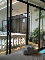 Quarto de hotel com vista para uma varanda, uma piscina e a paisagem urbana.
