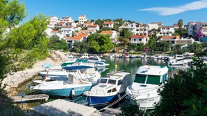 Marina com barcos atracados, rodeada por edifícios residenciais e vegetação.