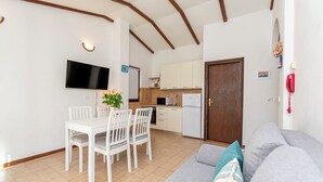 Um espaço compacto com área de jantar, cozinha compacta e sofá.