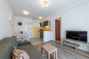 Apartamento, vista para o mar | Sala de estar | Televisor de ecrã plano de 100 cm com canais digitais