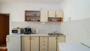Uma cozinha compacta com micro-ondas, cafeteira e pia.