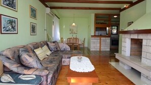 Uma sala de estar acolhedora com um sofá, uma mesa de centro de madeira e uma lareira.