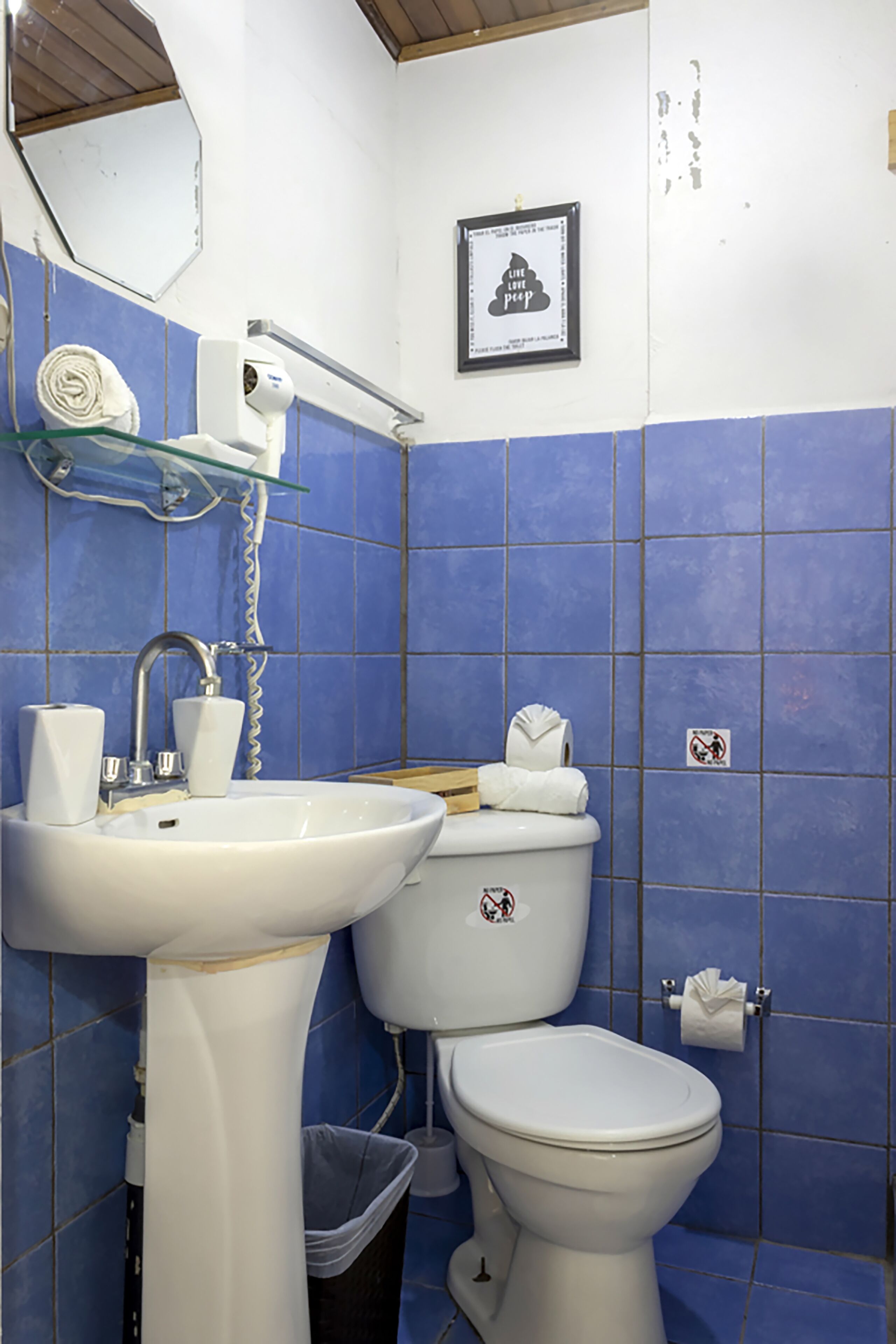 Casa de banho com lavatório branco, sanita e barra para toalhas.