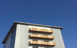Um edifício moderno com três varandas e telhado plano.