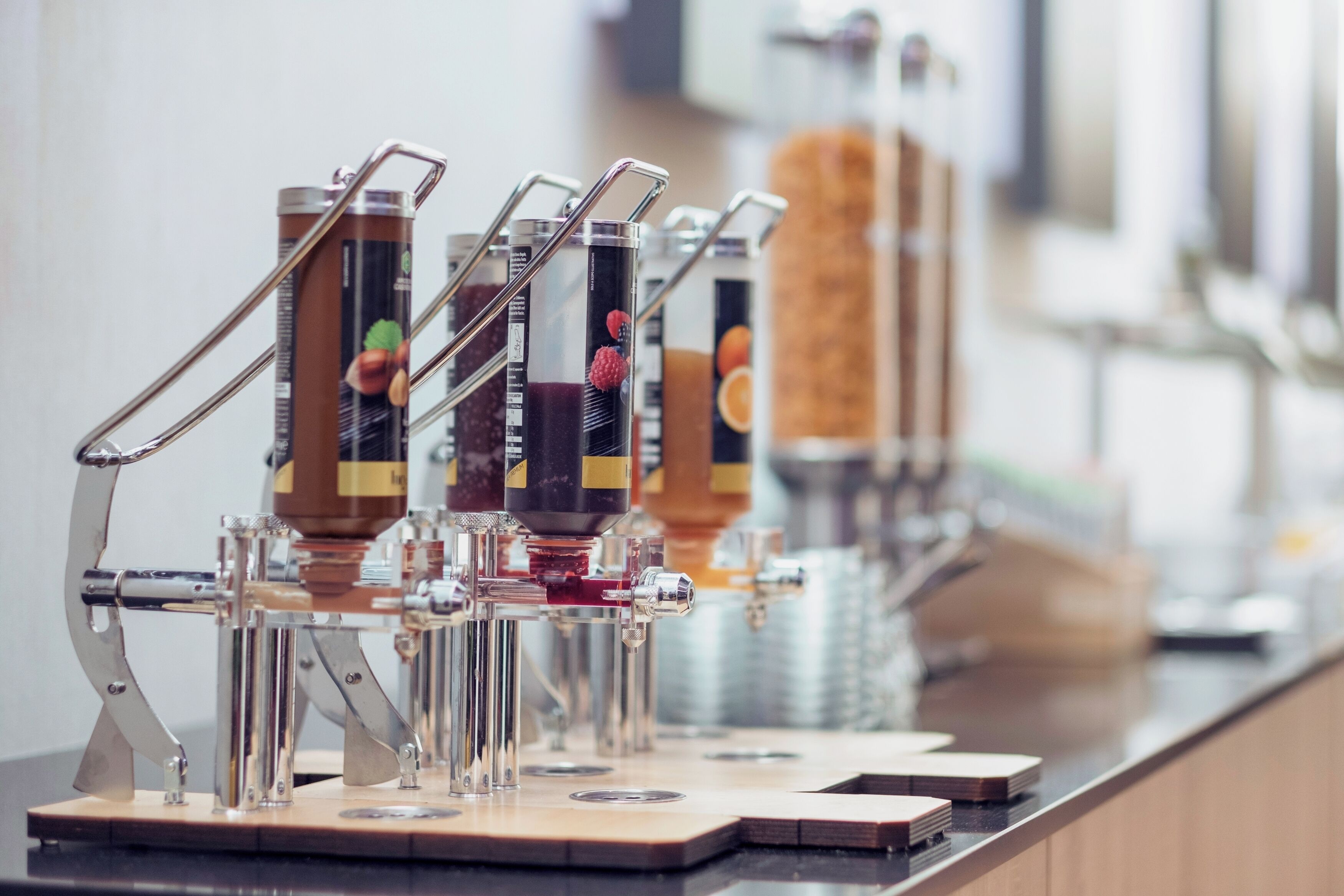 Máquina de café com vários dispensadores, cada um oferecendo uma opção de bebida diferente.