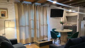 Uma sala de estar moderna com um conjunto de sofás, uma mesa de centro e um espaço de jantar com uma mesa redonda e cadeiras.