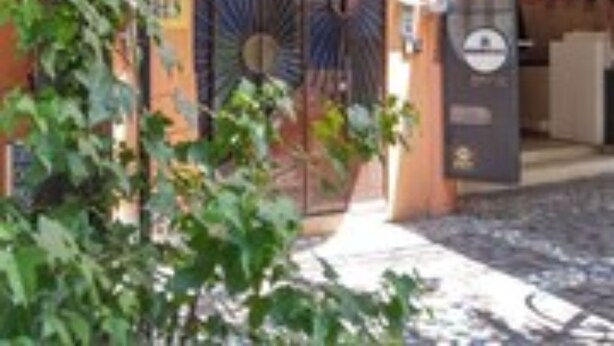 Um edifício com uma entrada arqueada marcante e uma porta grande e elaborada.