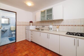 Apartamento (A3) | Cozinha privada | Geladeira, cooktop, talheres/pratos/utensílios de cozinha