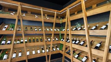 Prateleiras de adega com várias garrafas de vinho.