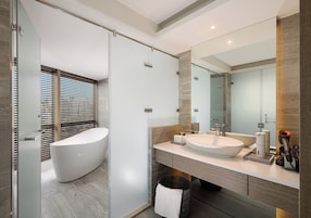 Quarto casal romântico, 1 cama King, banheira, vista para a cidade | Banheiro | Chinelos 