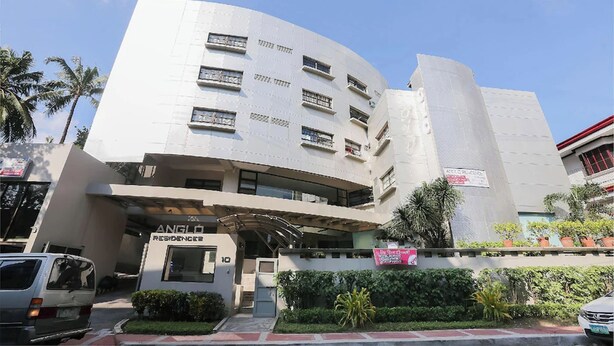 Um edifício moderno com fachada curva, várias varandas e uma placa indicando que é uma residência.