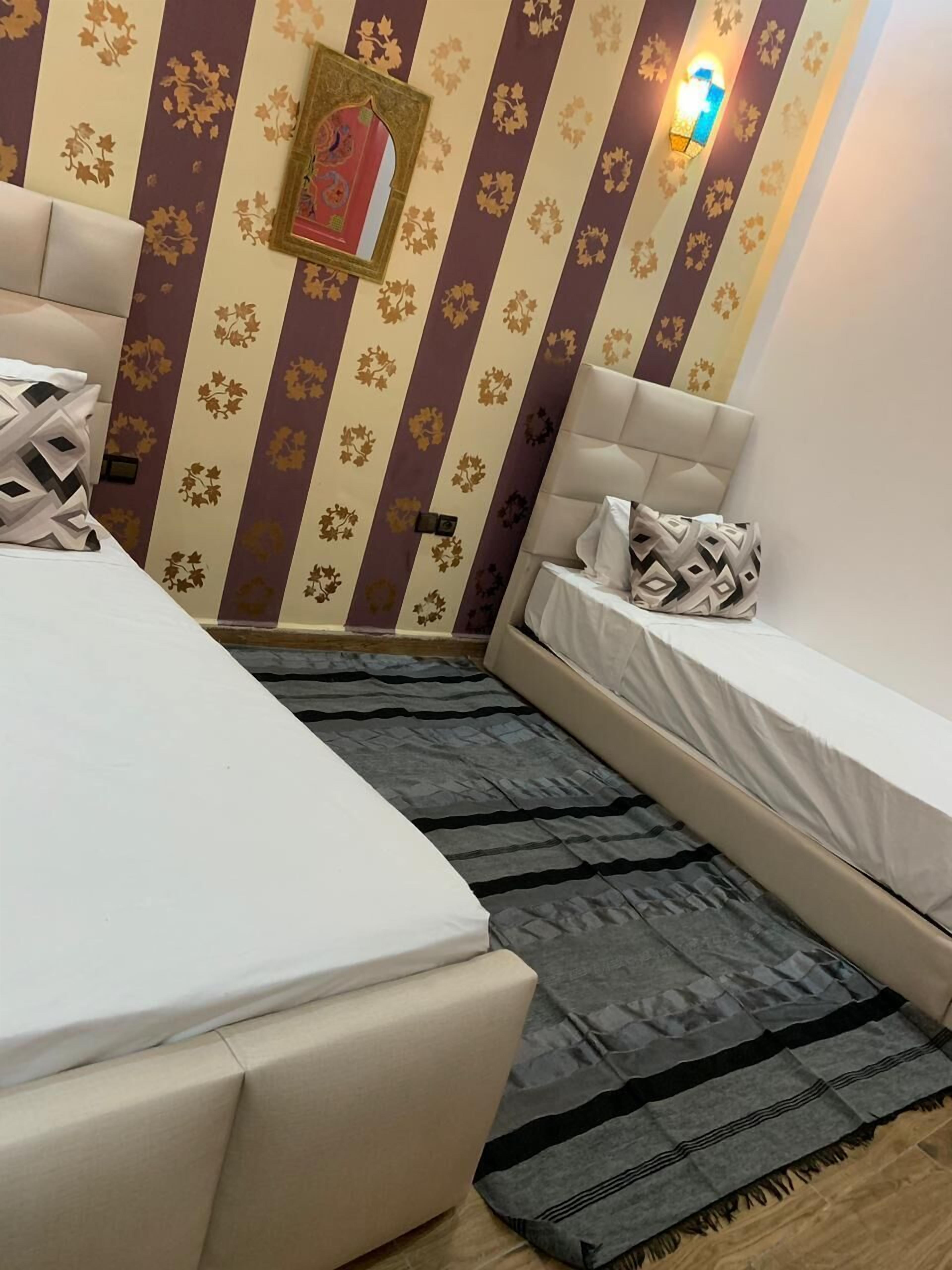 Um quarto com cama, sofá e mesa de cabeceira.