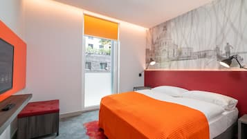 Quarto de hotel moderno com uma cama grande, uma parede de destaque vermelha, um mural com vista para a cidade, uma escrivaninha com controle remoto e um tapete vermelho.