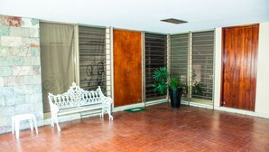 Quarto com um banco, uma planta em vaso e uma porta deslizante.