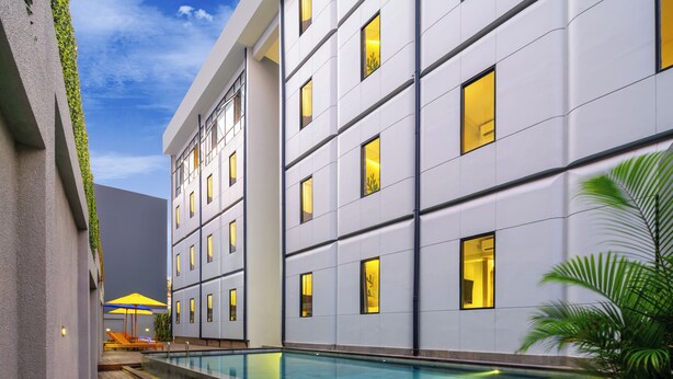 Um edifício moderno com piscina, janelas amplas e vista do céu.