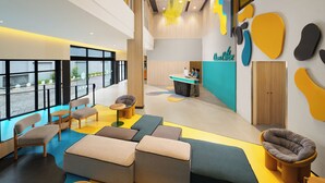 Um lobby moderno com balcão de recepção, áreas de estar e grandes janelas.