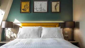Quarto de hotel com cama, duas luminárias laterais, mapa fixado na parede e quadro emoldurado.