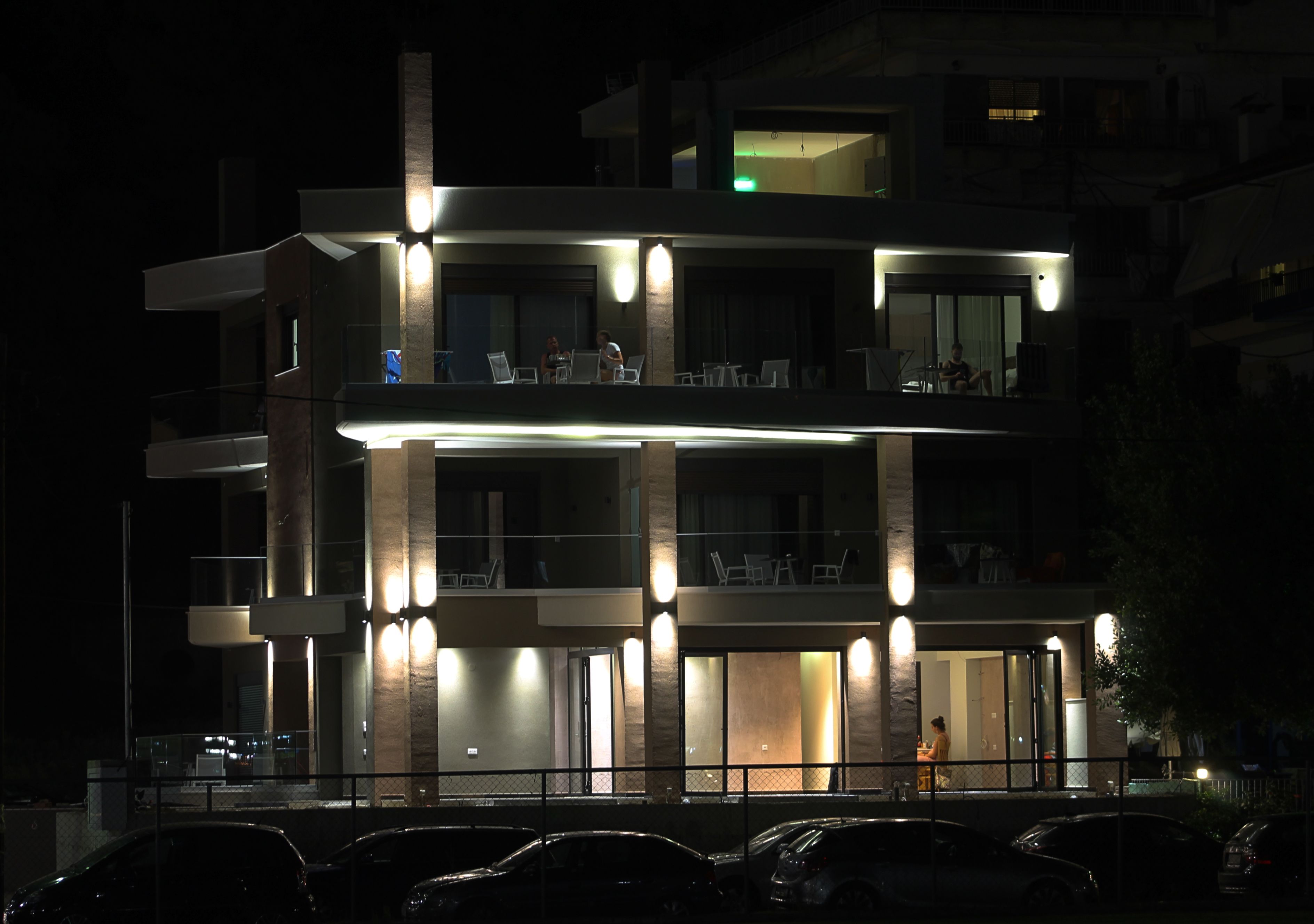 Um hotel de vários andares com varandas, janelas amplas e fachada bem iluminada à noite.