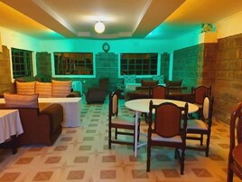 Um quarto aconchegante com uma mesa redonda e cadeiras, um sofá e uma lareira.