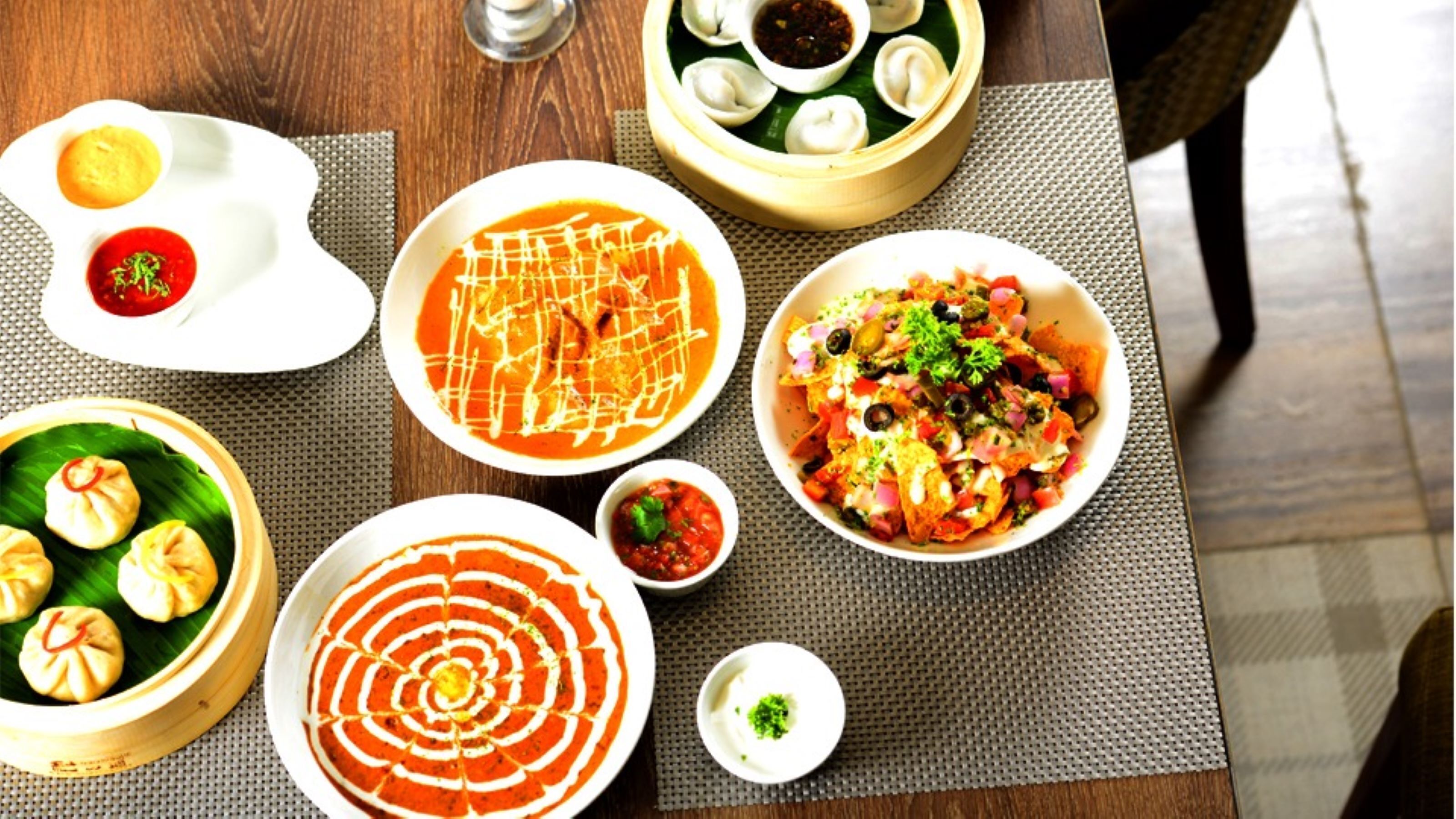 Uma mesa com diversos pratos, incluindo dumplings, sopa e salada.