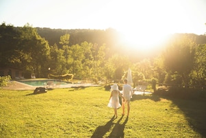 Uma área gramada com piscina e espreguiçadeiras.