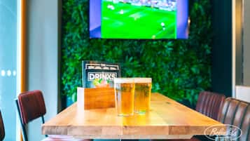 Uma mesa de madeira com duas cervejas e um cardápio.