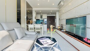 Uma sala de estar moderna com sofá, mesa de centro e uma TV exibindo 'NETFLIX'.