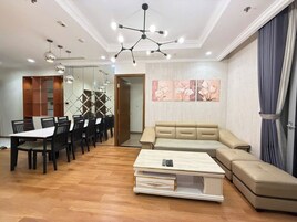 Uma sala de estar moderna com sofá, mesa de centro e área de jantar com cadeiras e mesa.