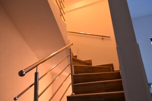 Uma escadaria com guarda-corpos de metal e degraus de madeira.