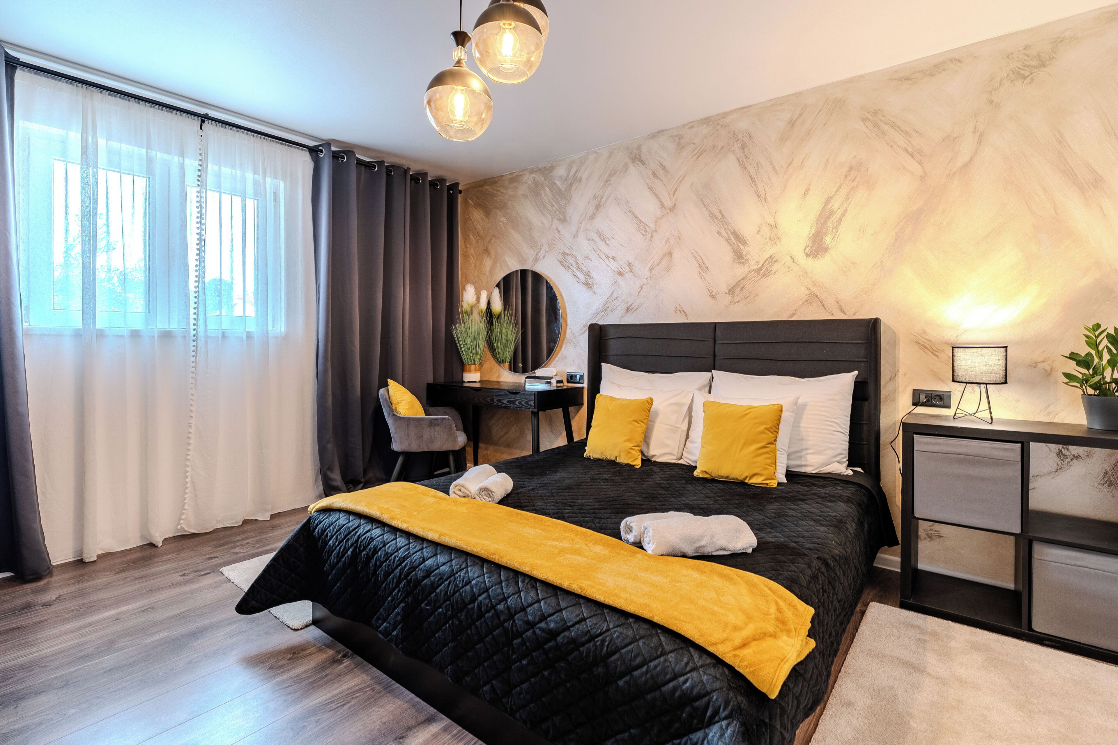 Quarto de hotel moderno com uma cama grande, uma escrivaninha e uma cadeira.