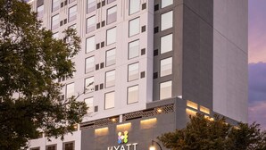 Um moderno hotel Hyatt Place com uma entrada notável, grandes janelas e uma placa visível.