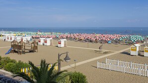 Uma praia com muitos guarda-sóis e cabanas coloridas.