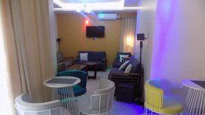 Uma sala de estar moderna com sofá, televisão de tela plana e ventilador de teto.