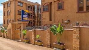 Hotel com placa, varanda e cerca de segurança.