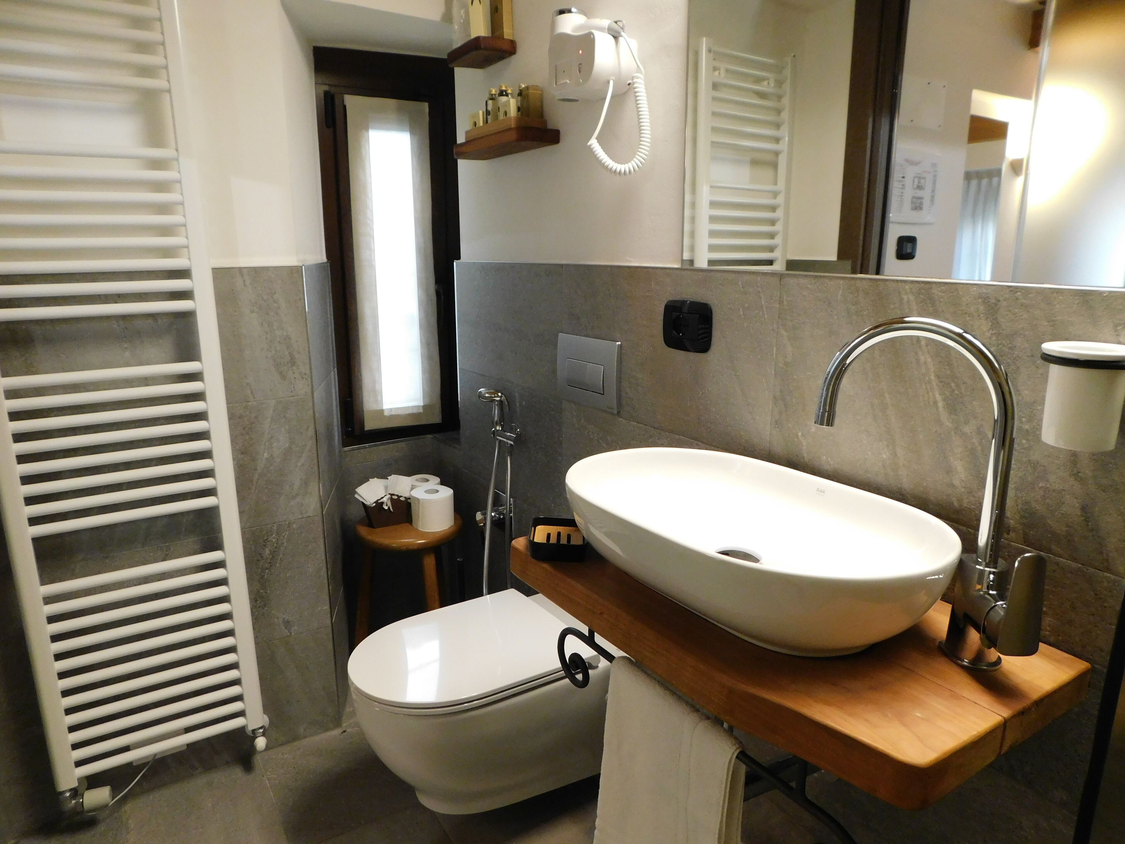 Uma casa de banho moderna com uma sanita, chuveiro e lavatório branco.