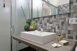 Um banheiro moderno com uma pia retangular grande, um espelho e um revestimento de azulejos.