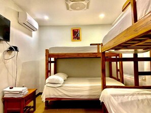 Quarto com beliche, televisão, ar condicionado e um pôster na parede.