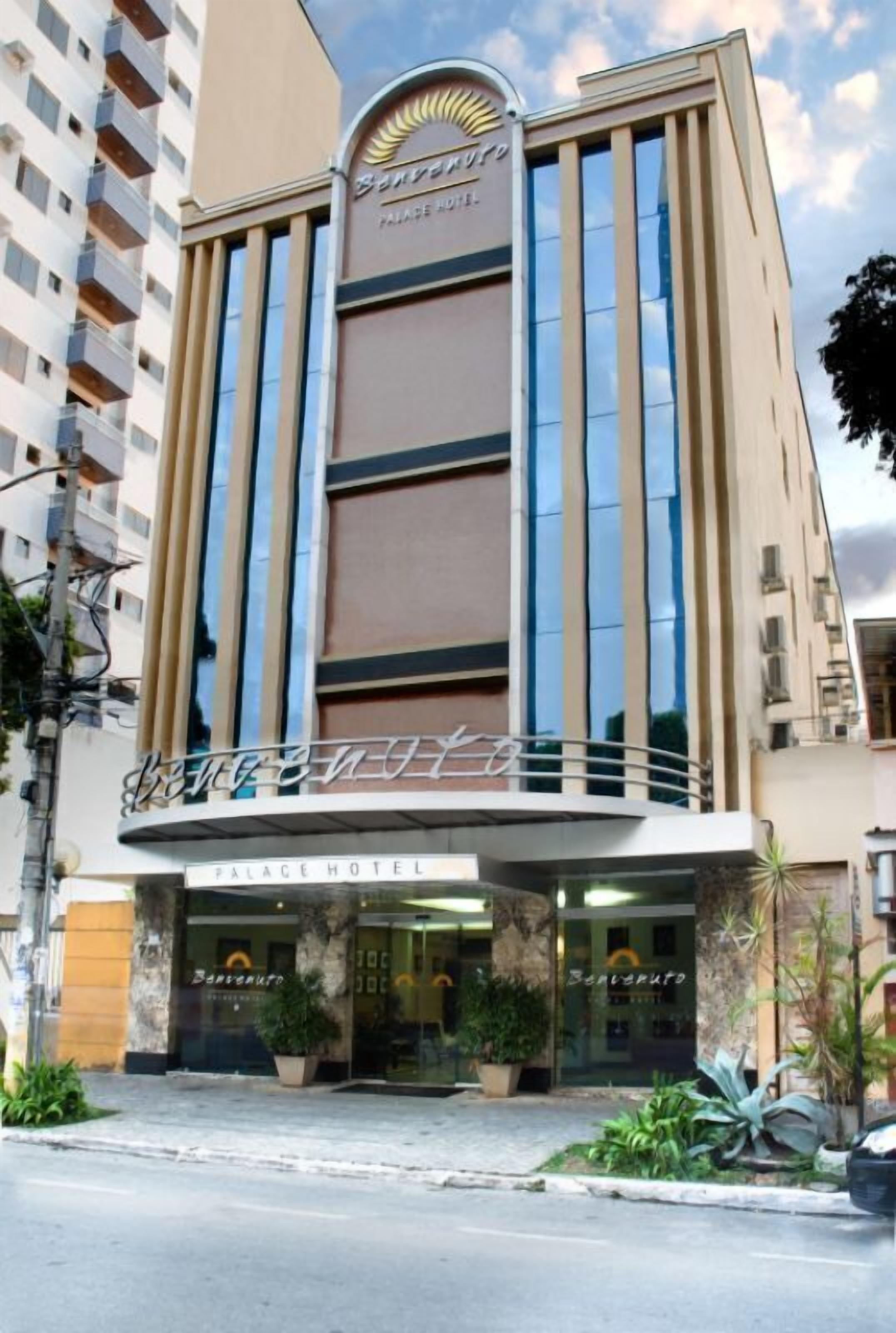 Um hotel com fachada moderna, exibindo um logotipo em destaque e o nome 'Palace Hotel' na entrada.